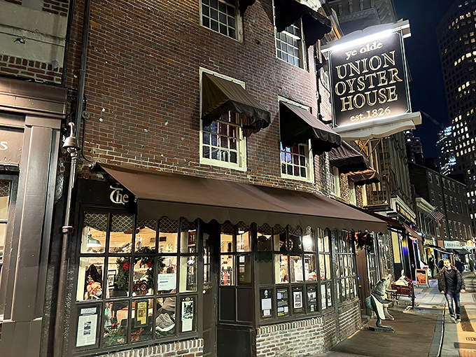 The historic brick facade of Union Oyster House glows with welcome as night falls, a culinary lighthouse that has guided hungry Bostonians since 1826.