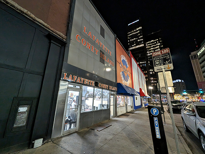 The iconic Lafayette Coney Island fa&ccedil;ade glows like a beacon for hungry night owls, promising Detroit's most famous comfort food against the city skyline.