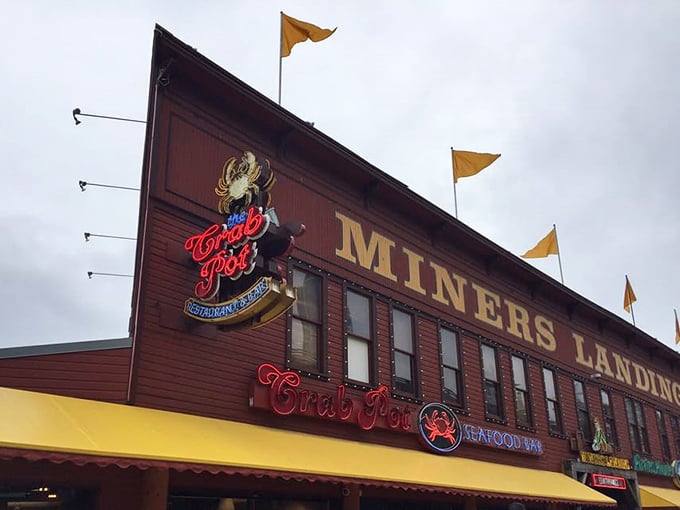 The iconic red crab sign beckons seafood lovers like a crustacean lighthouse on Seattle's waterfront, promising maritime delights within the rustic wooden building.