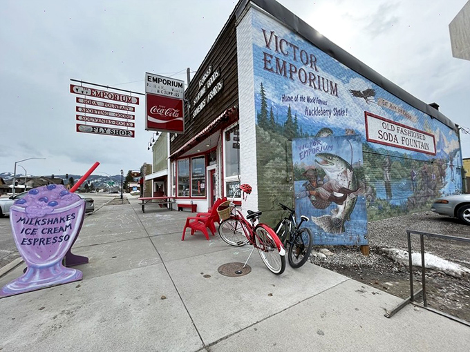 The mural-adorned exterior of Victor Emporium stands like a portal to simpler times, beckoning travelers with promises of icy purple perfection beneath Teton skies.