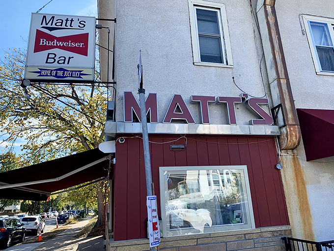 The unassuming exterior of Matt's Bar stands like a humble temple to burger perfection, its red and white facade hiding culinary treasures within.