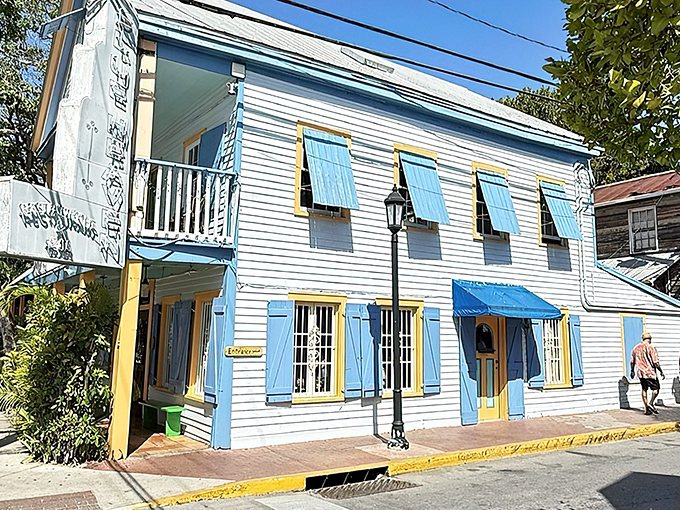 The iconic blue fence and hand-painted sign welcome you to Blue Heaven, where Key West's quirky spirit meets culinary paradise.