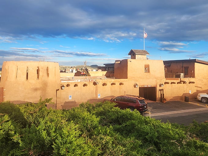 The Fort's adobe entrance glows with warmth against the night sky, luminous farolitos beckoning hungry travelers to step back in time at 6,100 feet elevation.