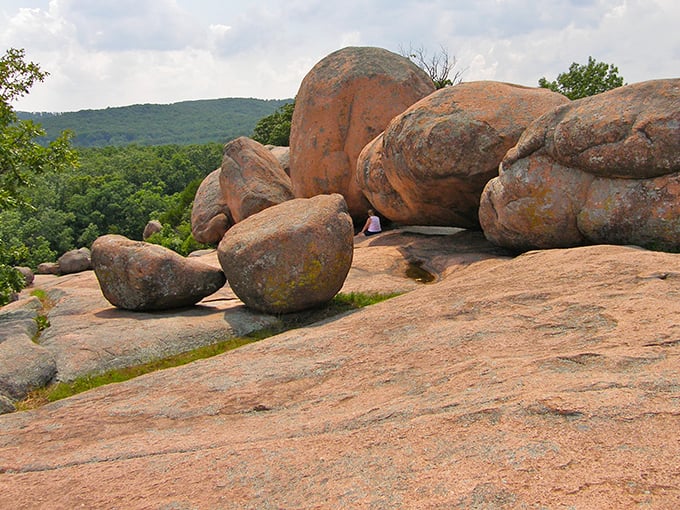 Nature's sculpture garden spans the horizon, where billion-year-old pink granite boulders rest like gentle giants against Missouri's emerald landscape. 