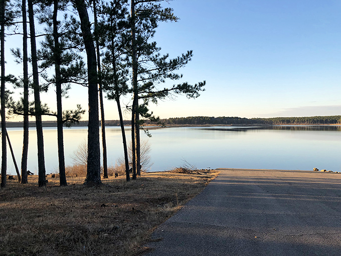 Mirror-like waters reflect the forested shoreline at McGee Creek Reservoir, where silence is only broken by the occasional splash of a jumping bass.