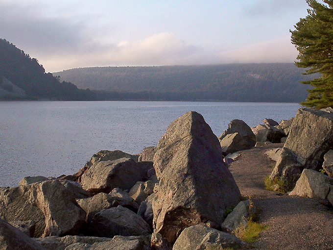 The shoreline tells ancient stories in stone. Devil's Lake's crystal waters meet million-year-old quartzite in nature's perfect handshake.
