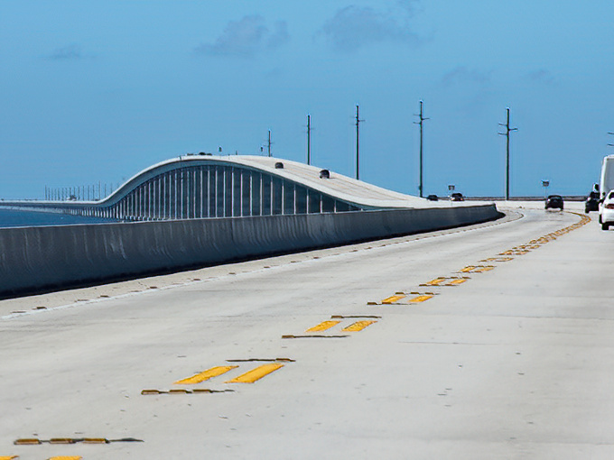 The highway seemingly floats between two infinite blues, making you question whether you're still on Earth or have somehow driven into a postcard.
