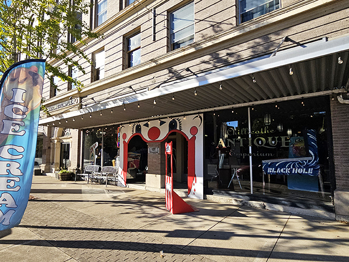 The storefront beckons like a time portal, with mid-century furniture artfully arranged behind glass and that glowing "Chillicothe ANTIQUE" sign promising adventures in nostalgia.