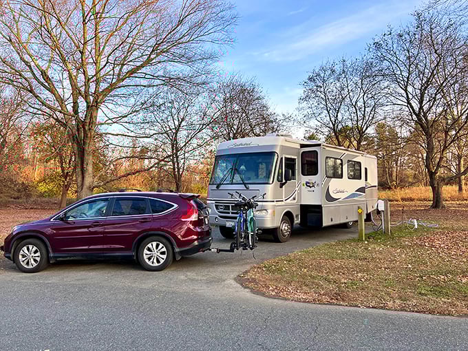 Fall magic at its finest! A hot air balloon drifts over Lums Pond campground, where autumn trees create nature's most spectacular color palette.