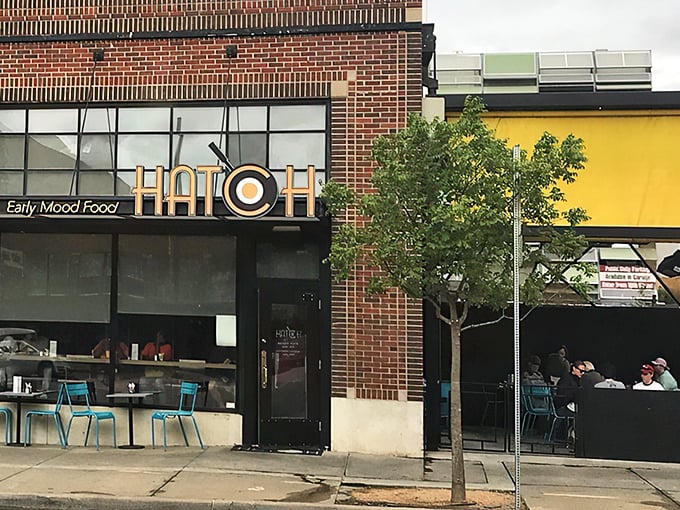 The golden glow of Hatch's signage beckons like a breakfast lighthouse. Those blue chairs aren't just seating&mdash;they're your front-row tickets to the morning's main event.