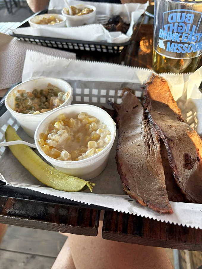 Slices of brisket with perfect pink smoke rings flanked by cups of corn, telling the timeless story of carnivorous joy in Middle America.