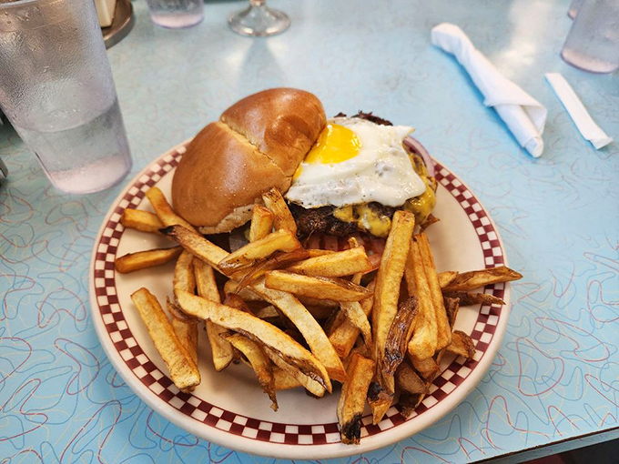 The burger arrives with a sunny-side-up egg playing king of the mountain, while hand-cut fries spread out below like devoted subjects.
