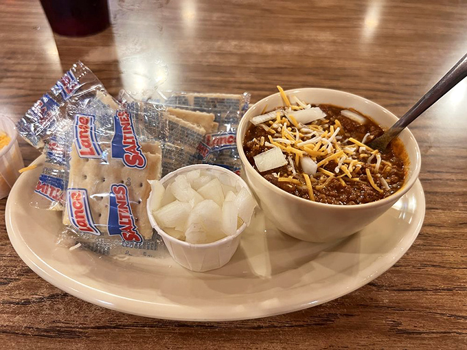 A bowl of chili topped with melted cheese and served with crackers and onions – Oklahoma's answer to winter blues and empty stomachs.