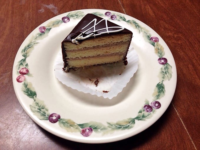Layer cake perfection—vanilla sponge and chocolate ganache playing their classic duet on grandma's china, because some traditions deserve proper presentation.