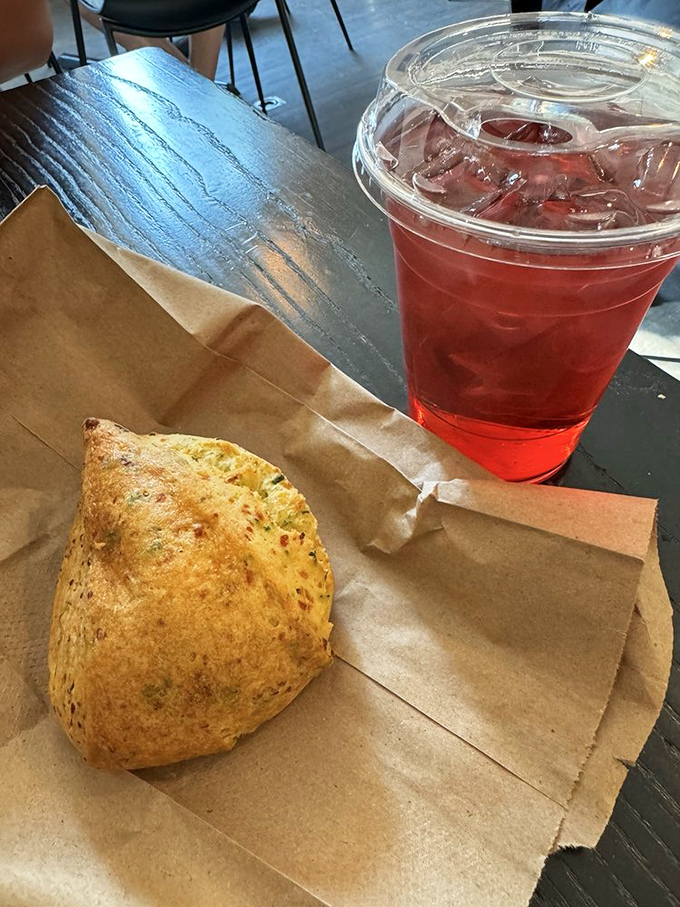 That vibrant raspberry tea looking like liquid jewels next to a scone that means serious business.
