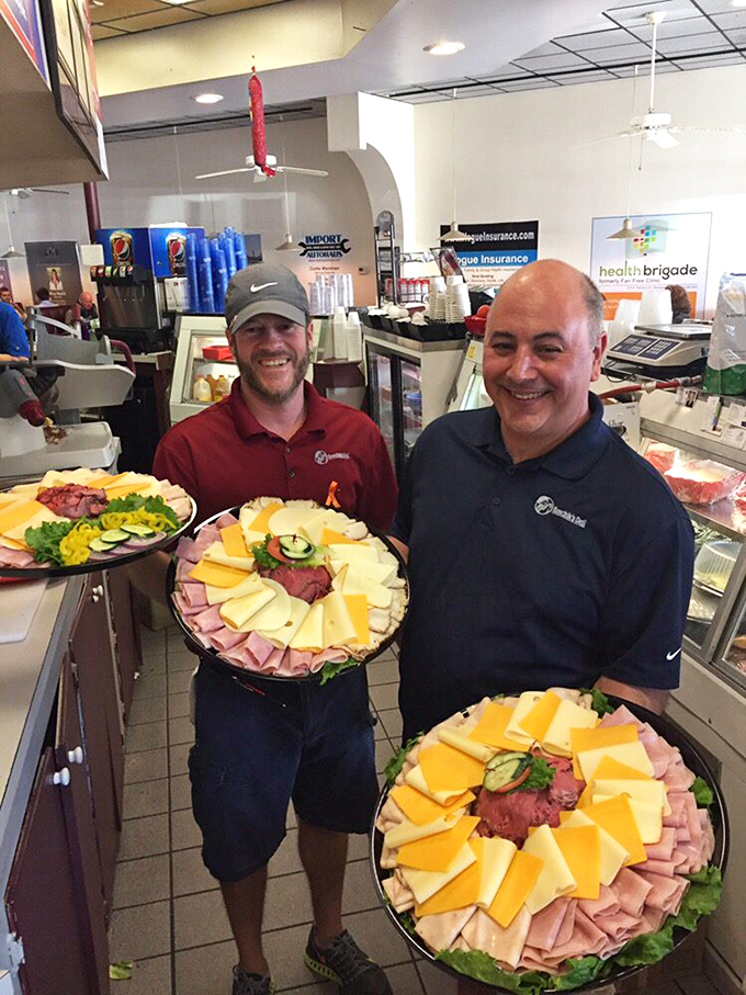 The maestros behind the counter, proudly displaying their catering platters. These are the sandwich architects your taste buds have been waiting for.