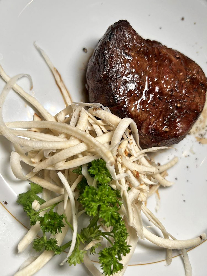 A filet mignon so perfectly cooked it practically cuts itself, paired with those signature crispy shoestring potatoes that disappear mysteriously fast.
