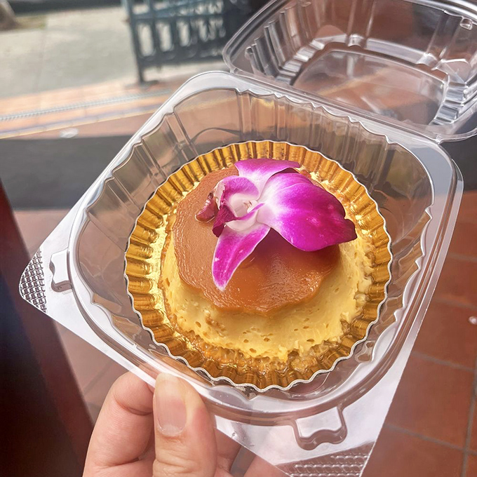 The flan wears its caramel crown with the confidence of dessert royalty, while that orchid garnish adds a touch of tropical elegance.