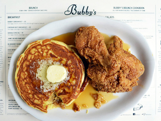 The ultimate brunch power couple: golden pancakes and crispy fried chicken sharing a plate in the culinary equivalent of Katharine Hepburn and Spencer Tracy.