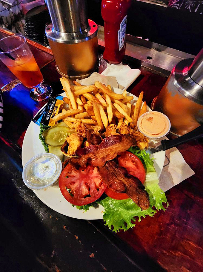 This isn't just a sandwich, it's architecture - layers of crispy fried goodness stacked between fresh vegetables and what appears to be seafood perfection.