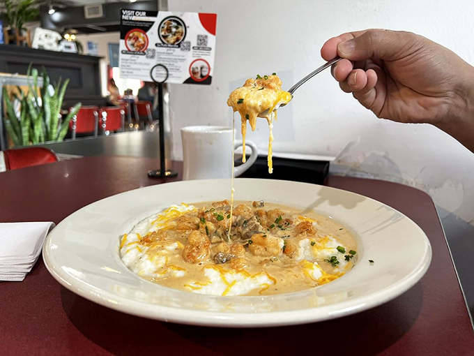 Creamy grits supporting plump shrimp in a cheesy embrace. That spoonful being lifted tells the whole story&mdash;this is stretch-pants territory.