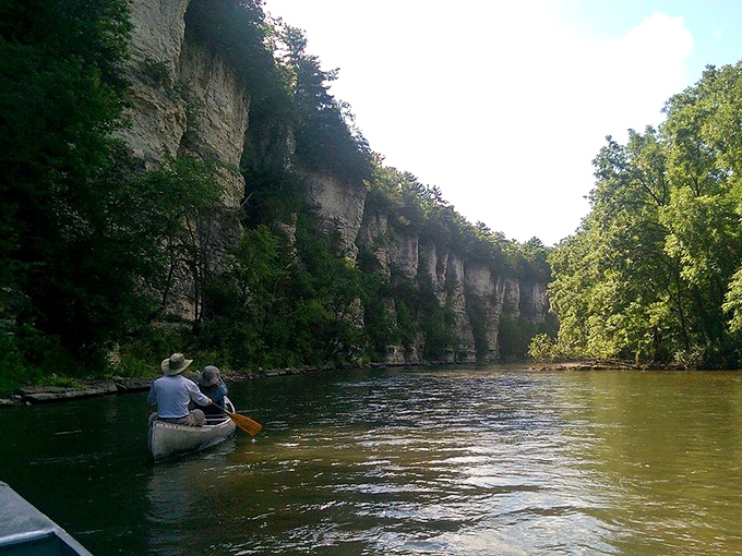 Limestone bluffs create nature's cathedral walls along the Upper Iowa River. These paddlers aren't just sightseeing&mdash;they're having a spiritual experience.