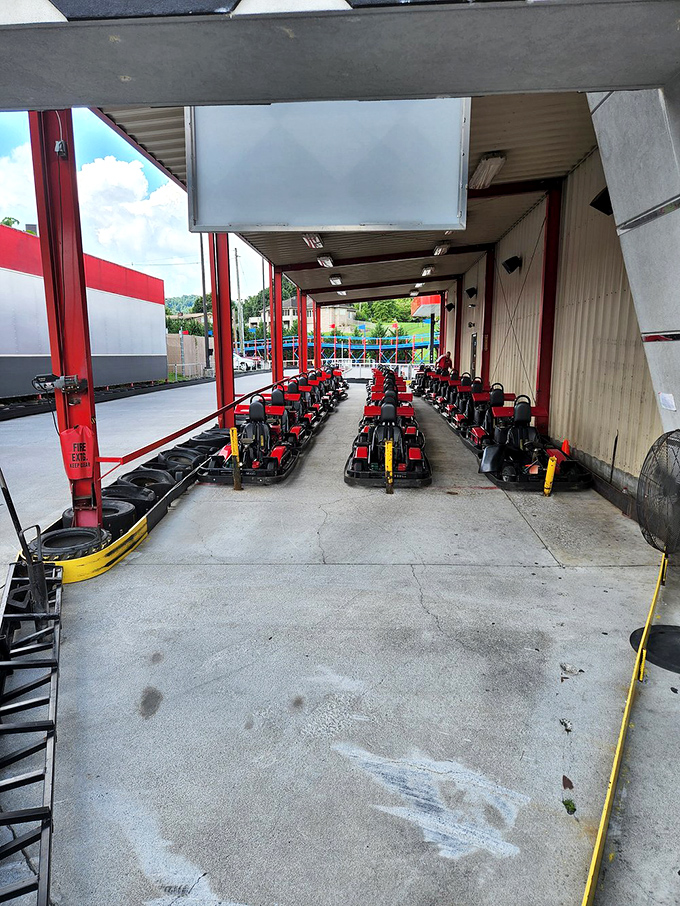The pit stop area where karts rest between battles. Like racehorses in their stables, these mechanical beasts await their next chance to run.