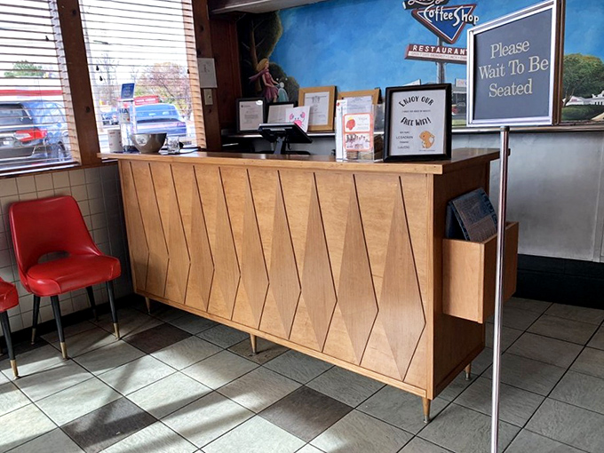 The host stand: where hope begins and hunger ends. That "Please Wait To Be Seated" sign is the last obstacle between you and breakfast bliss.