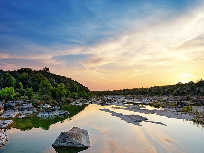 The Pedernales River catches golden hour light like liquid amber, transforming ordinary limestone into nature's perfectly composed postcard.