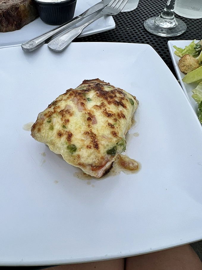 This salmon souffl&eacute; rises to the occasion with golden-brown perfection, sitting in a delicate pool of sauce that demands to be savored.