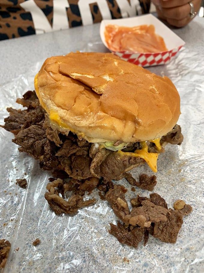 Not just a steak sandwich but a commitment to excess&mdash;meat spilling rebelliously from its bun like it's making a break for freedom.