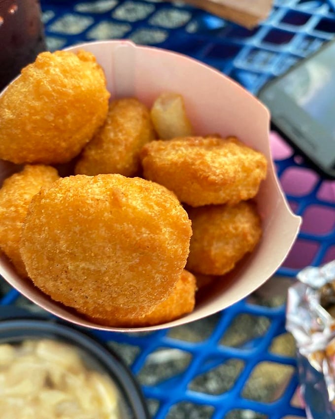 Golden hush puppies nestled in their paper boat, waiting to be devoured. These crispy cornmeal delights are the unsung heroes of any barbecue feast.