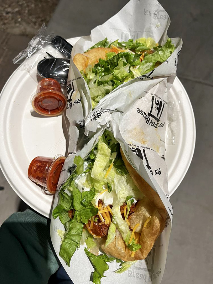 Al fresco dining with fry bread tacos. Fresh lettuce, seasoned meat, and that signature golden bread&mdash;proof that the best meals sometimes come on paper plates.