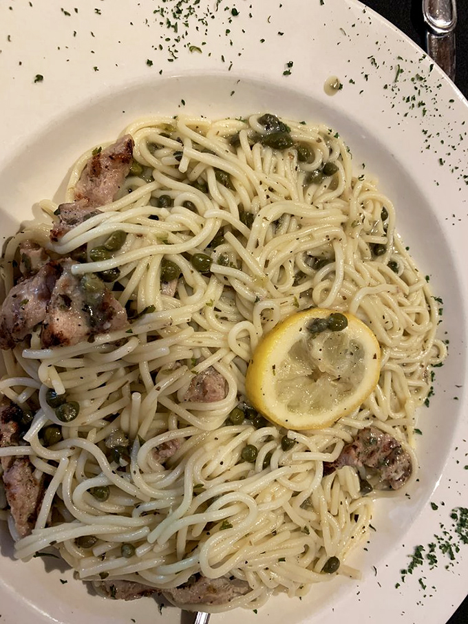 Veal piccata where pasta plays supporting actor to tender meat and bright capers. That lemon slice isn't just garnish &ndash; it's essential character development.