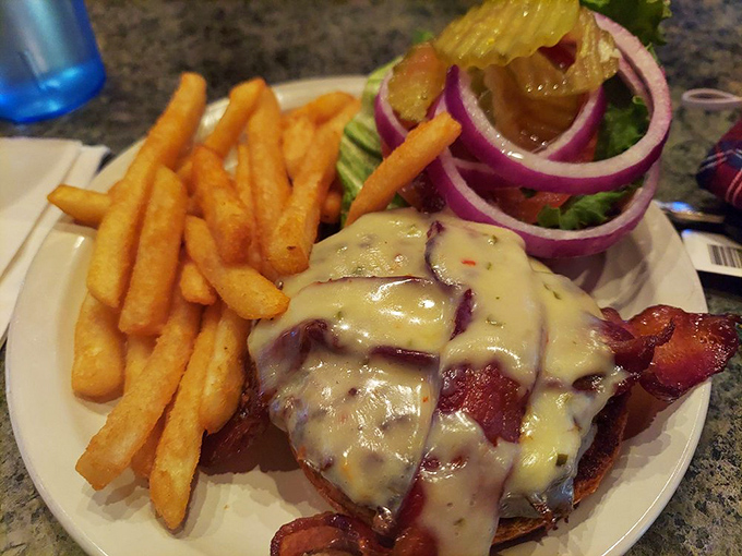 A burger that requires jaw exercises before attempting. That melted cheese cascade is performing gravity-defying feats worthy of a Vegas show.