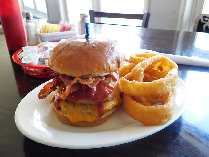 This burger with onion rings isn't just a meal &ndash; it's a tower of power that demands both respect and extra napkins.