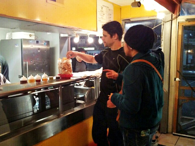 The universal language of anticipation. That moment before your order arrives when strangers become temporary allies in hunger.