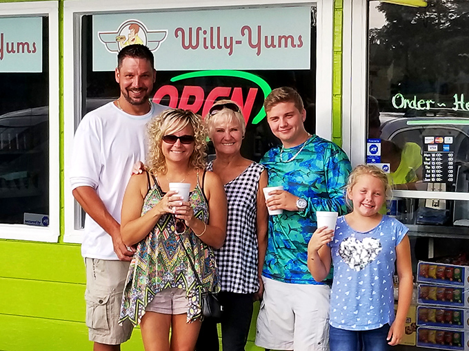 Happy customers outside Willy-Yums with drinks in hand. That smile says what words can't&mdash;"I've found my happy place, and it serves hot dogs."