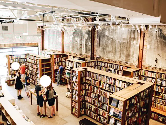 The high ceilings create a cathedral-like atmosphere, where browsing books becomes a reverent act under the watchful gaze of spherical lamps.
