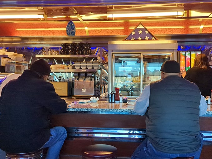 Counter seats: where strangers become neighbors and the American flag reminds you that diner culture might be our greatest national treasure.
