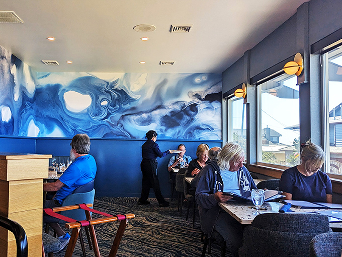 The blue ocean-inspired wall mural creates a dining atmosphere where your meal comes with a side of artistic appreciation.