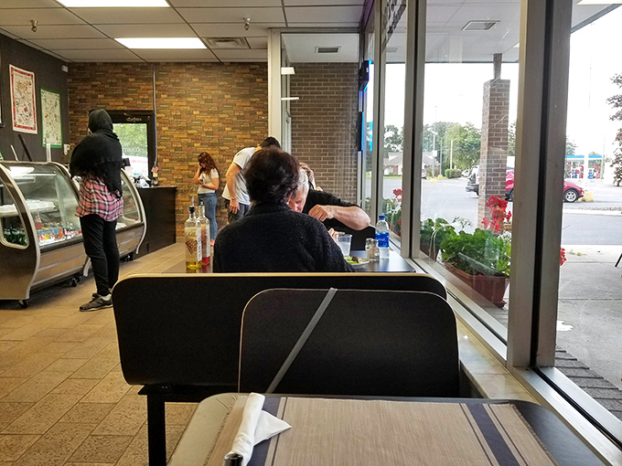 The view from inside reveals the simple pleasure of dining al fresco under striped umbrellas. Michigan summer, Italian style.