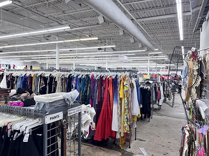 The children's section explodes with primary colors and tiny garments, a miniature wardrobe wonderland where baby walkers mingle with onesies and tiny shoes. 