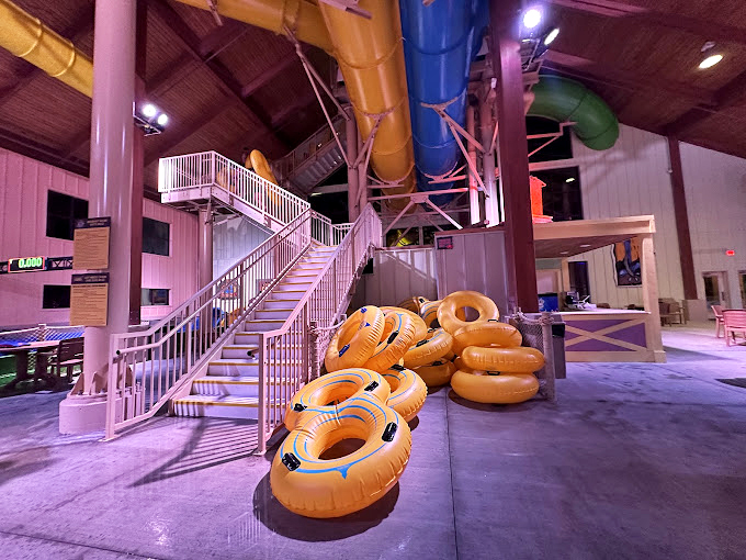 Those yellow inner tubes stacked like donuts aren't just pool accessories &ndash; they're vessels of joy waiting to transform adults into giggling ten-year-olds again.