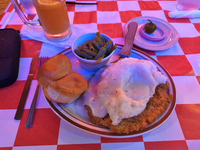 Southern comfort on a plate: country-fried steak smothered in gravy with green beans and rolls. Grandma would approve, then ask for seconds.