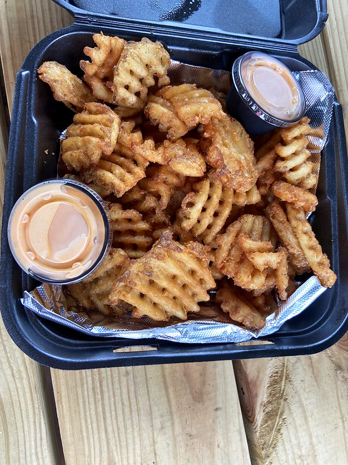 Waffle fries that crunch like autumn leaves, with dipping sauce that makes you question why you've wasted time on lesser potatoes.