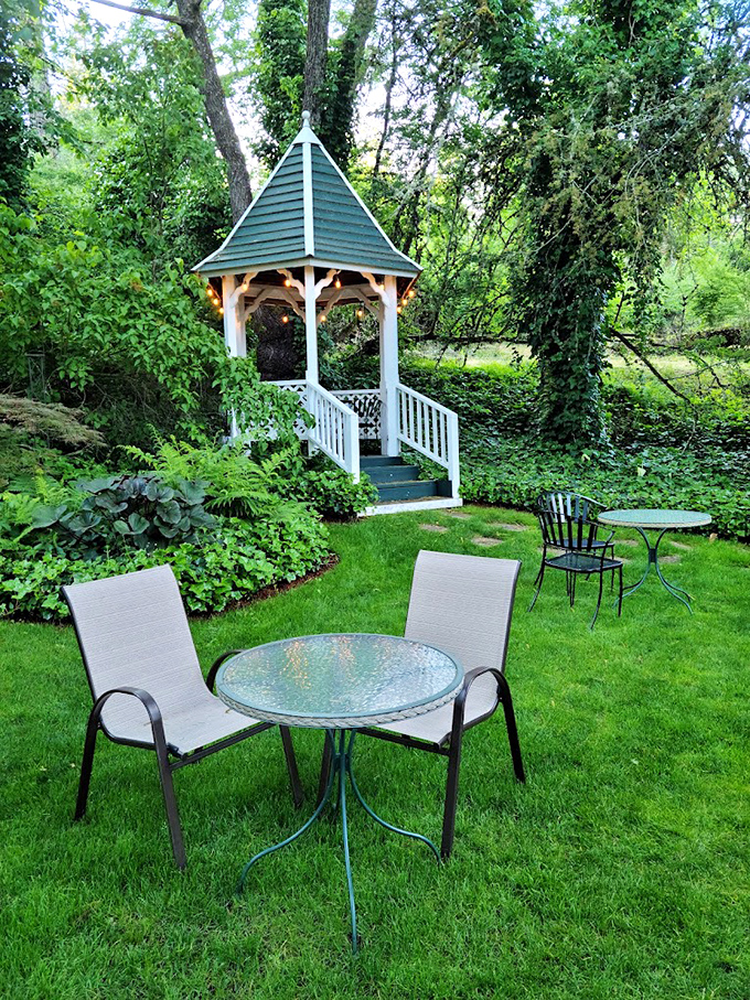 The inn's garden patio, where afternoon tea becomes an excuse to judge other guests' vacation outfits while pretending to read. 