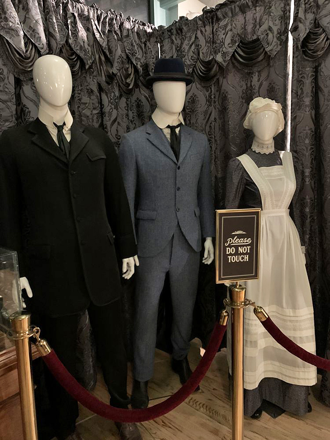 Period costumes on display remind visitors of the era when building code violations were considered creative expression rather than safety hazards.