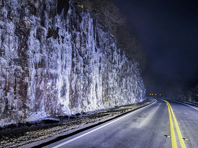 Winter transforms familiar routes into otherworldly passages. This ice-glazed rock wall glows like nature's own light installation against the night sky.