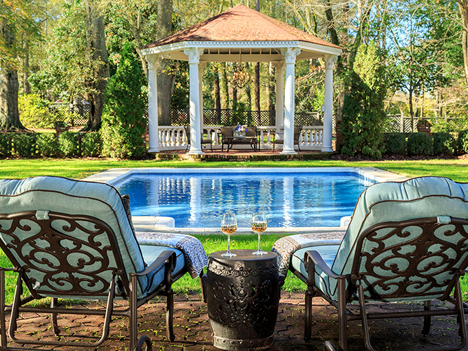 Paradise found: a sparkling pool with gazebo backdrop. Two chairs positioned for maximum relaxation and minimum responsibility.